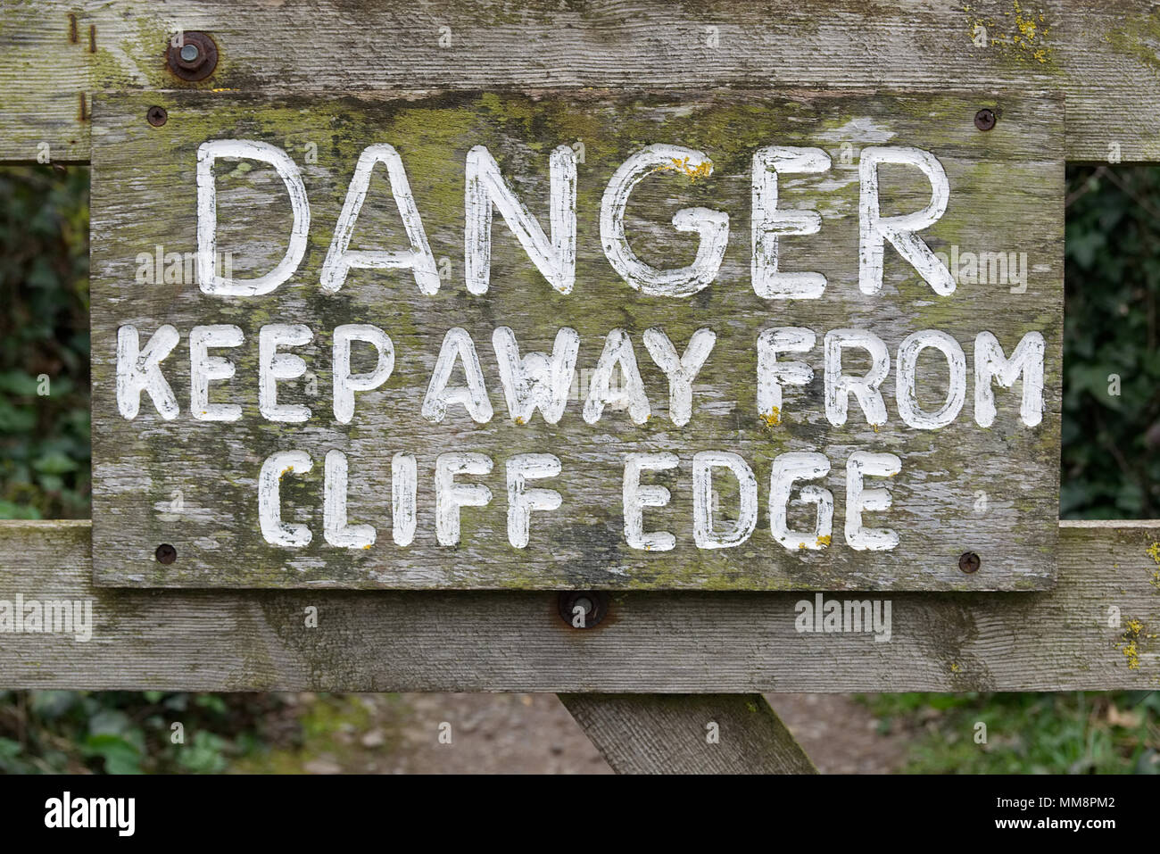 Weathered wooden DANGER KEEP AWAY FROM CLIFF EDGE sign with white ...