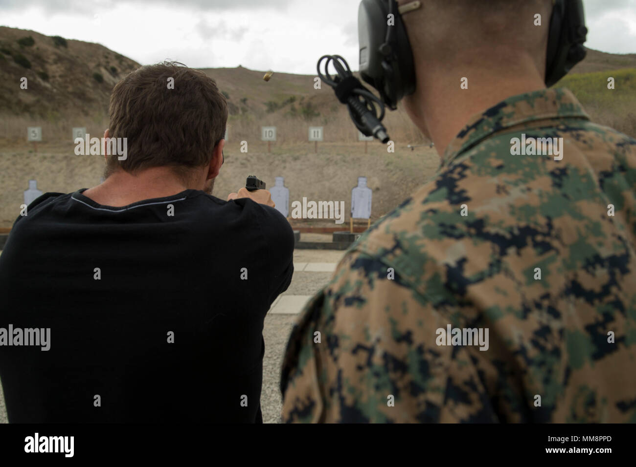 A U. S. Marine with 1st Marine Raider Support Battalion assists family ...