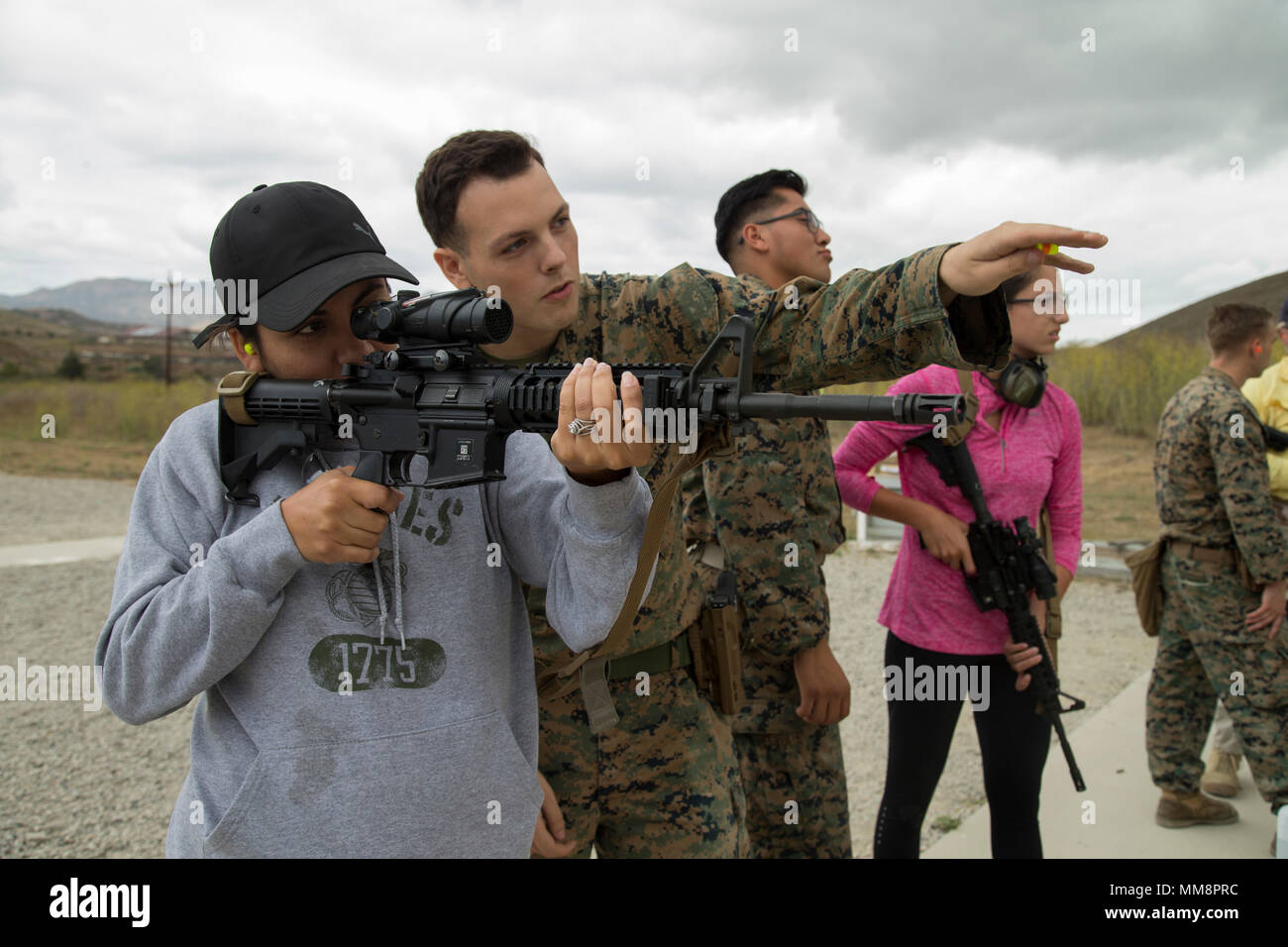 A U. S. Marine with 1st Marine Raider Support Battalion assists family ...
