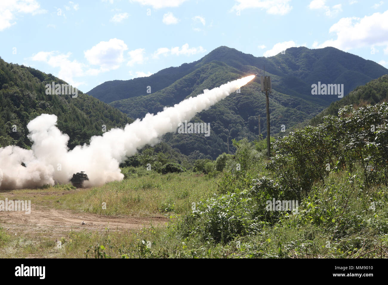 An M270 multiple launch rocket system fires during a live fire exercise ...