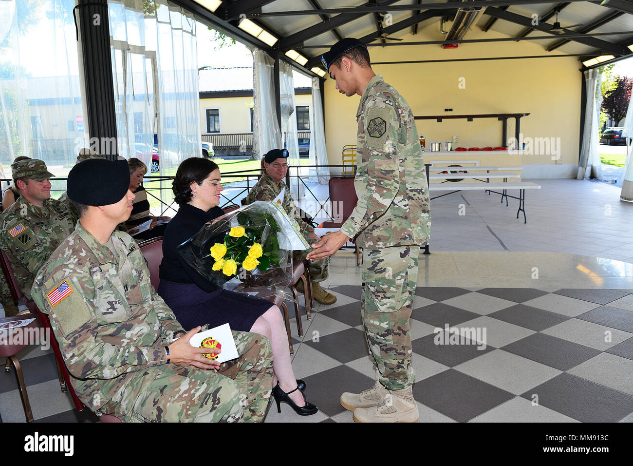 The wife of incoming commander, Capt. Eric P. Ng, receives a bouquet of ...
