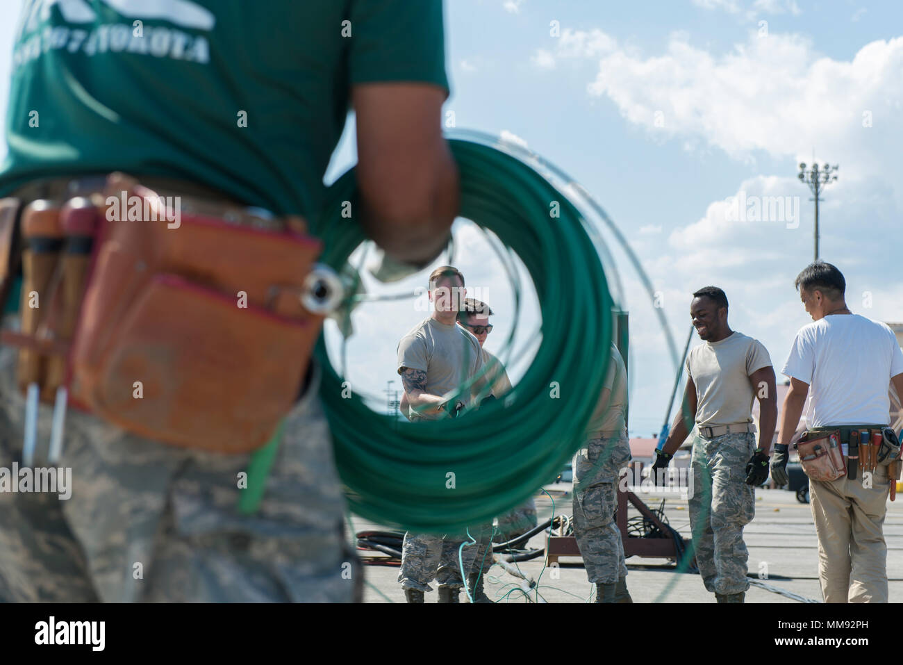 Members of the 374th Civil Engineer Squadron prepare a grounding cable ...
