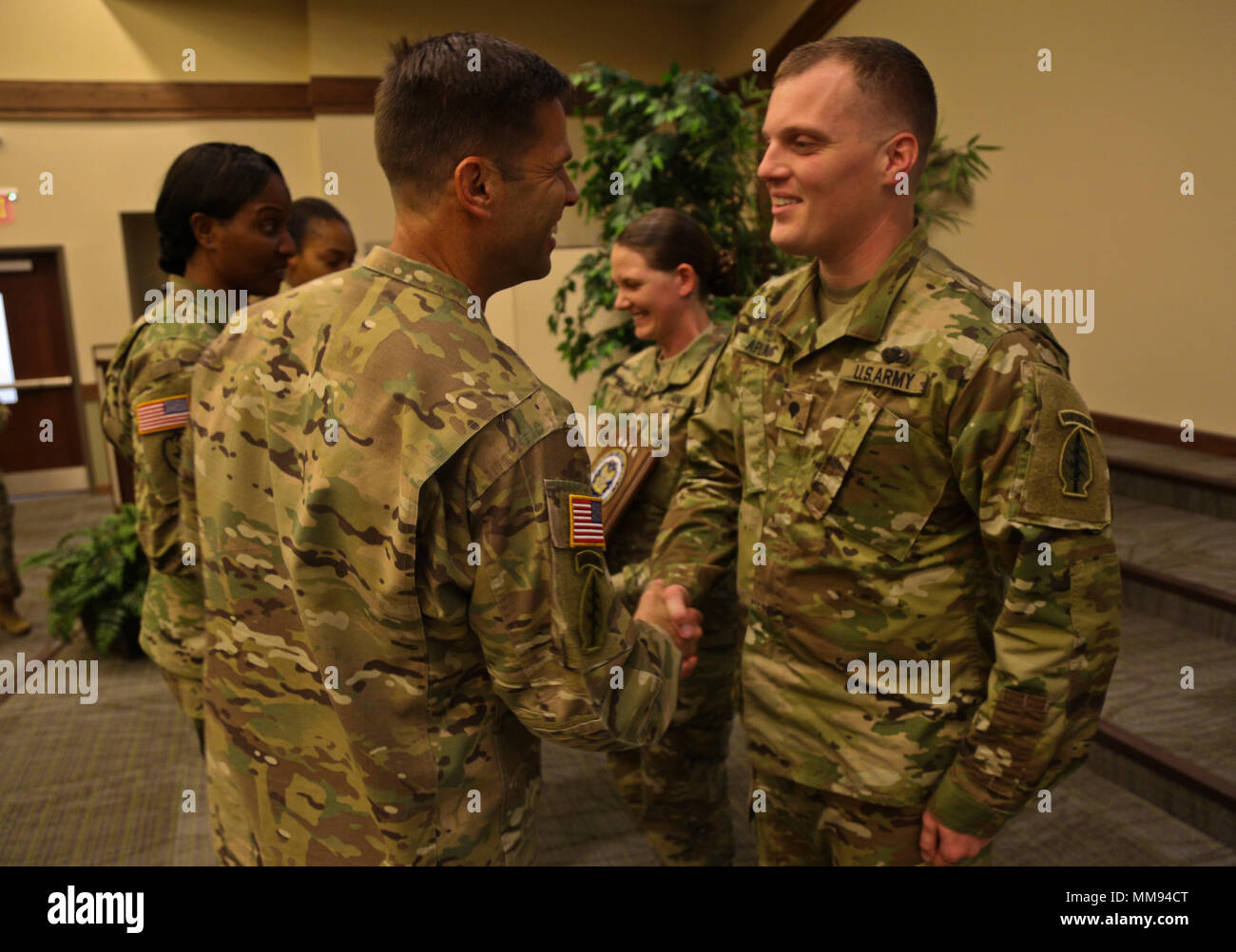 Col. Richard E. Angle gives a congratulatory handshake to supply ...