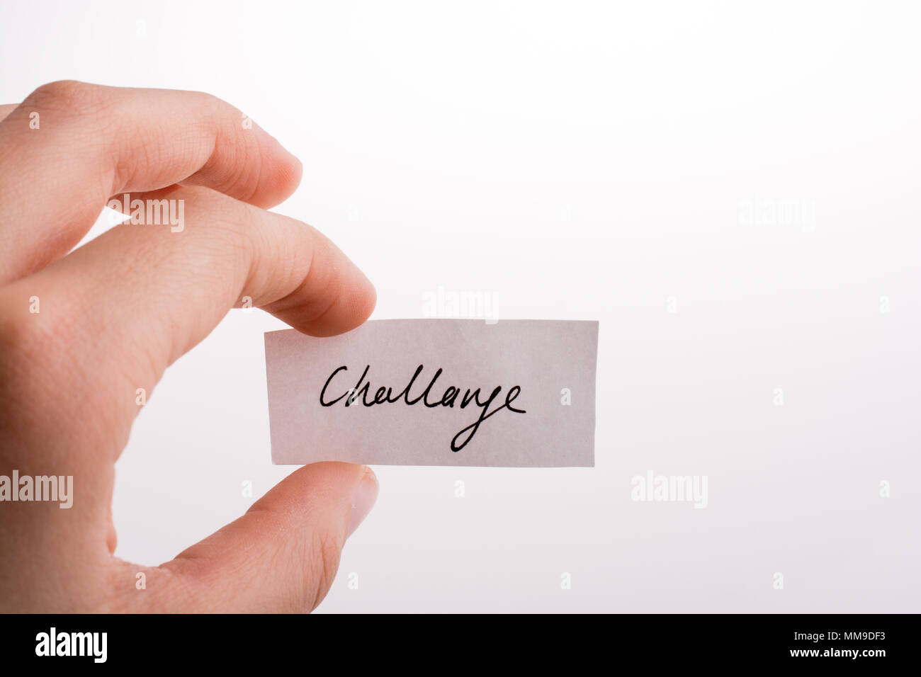 Hand holding a challenge written paper on a white background Stock ...