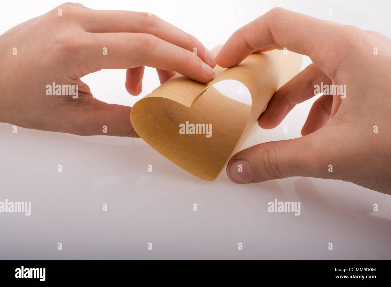 Paper forming a heart shape in hand on a white background Stock Photo ...