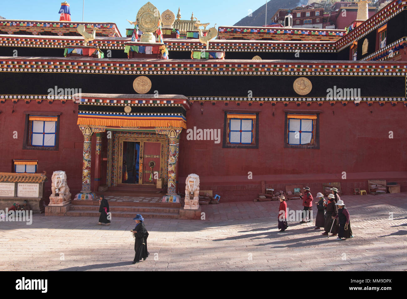 Tibetan pilgrims walk kora circles around the holy Bakong Scripture ...