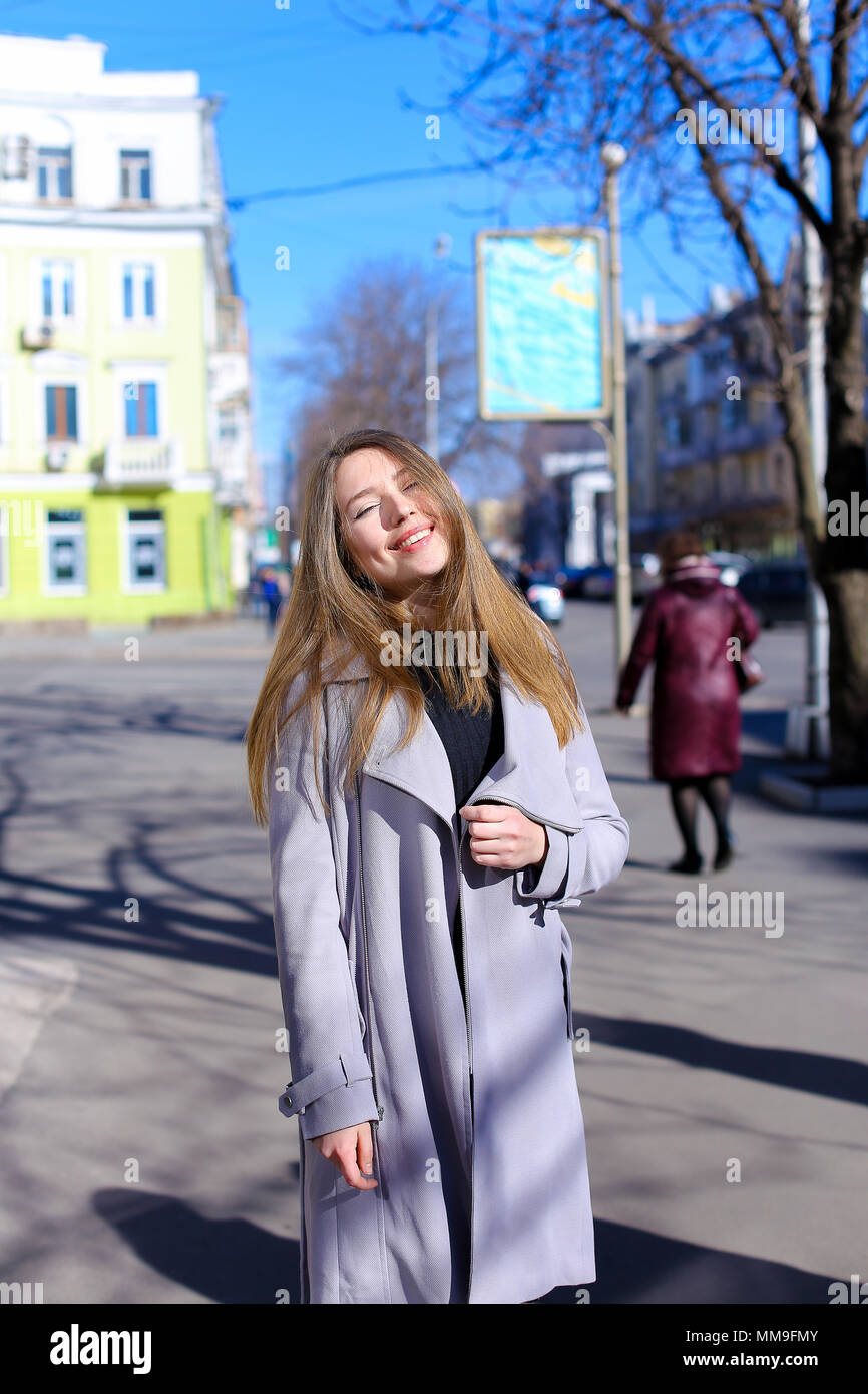 Nice lady strolling outdoors and wearing grey coat with black dress ...