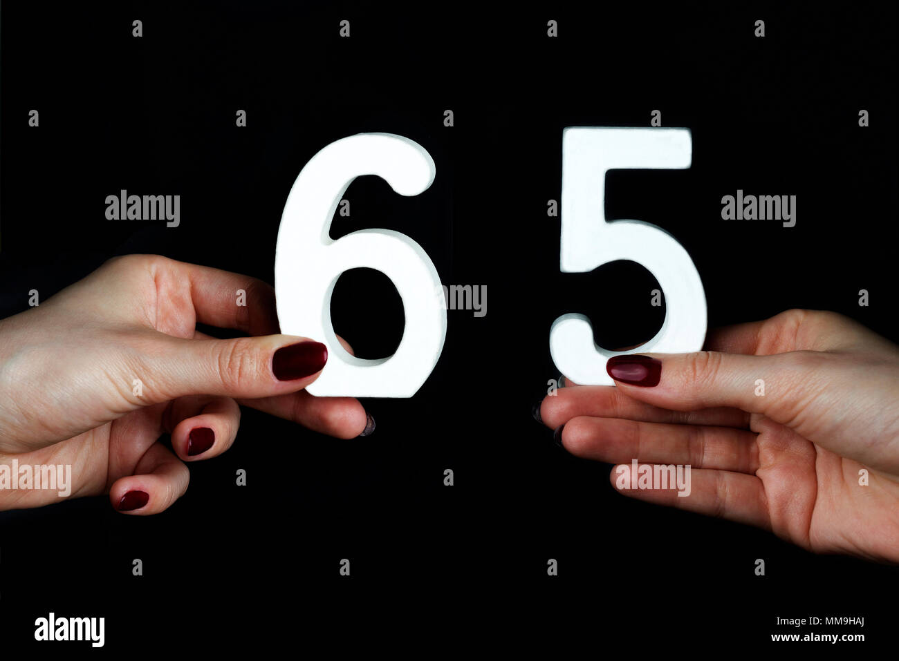 On a black background, female hand with the number sixty-five Stock ...