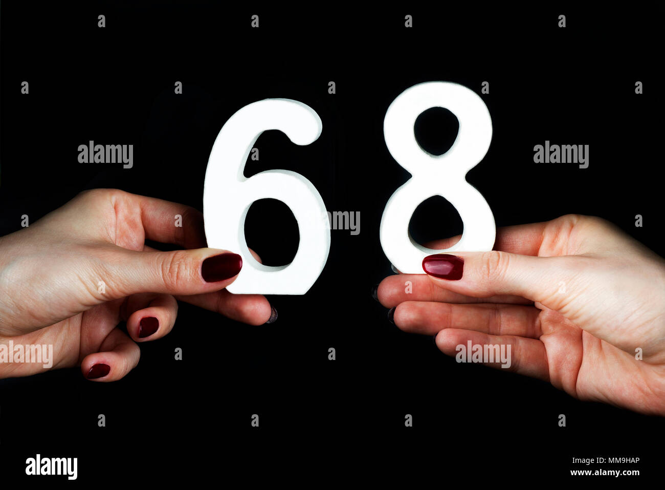 On a black background, female hand with number sixty-eight Stock Photo ...