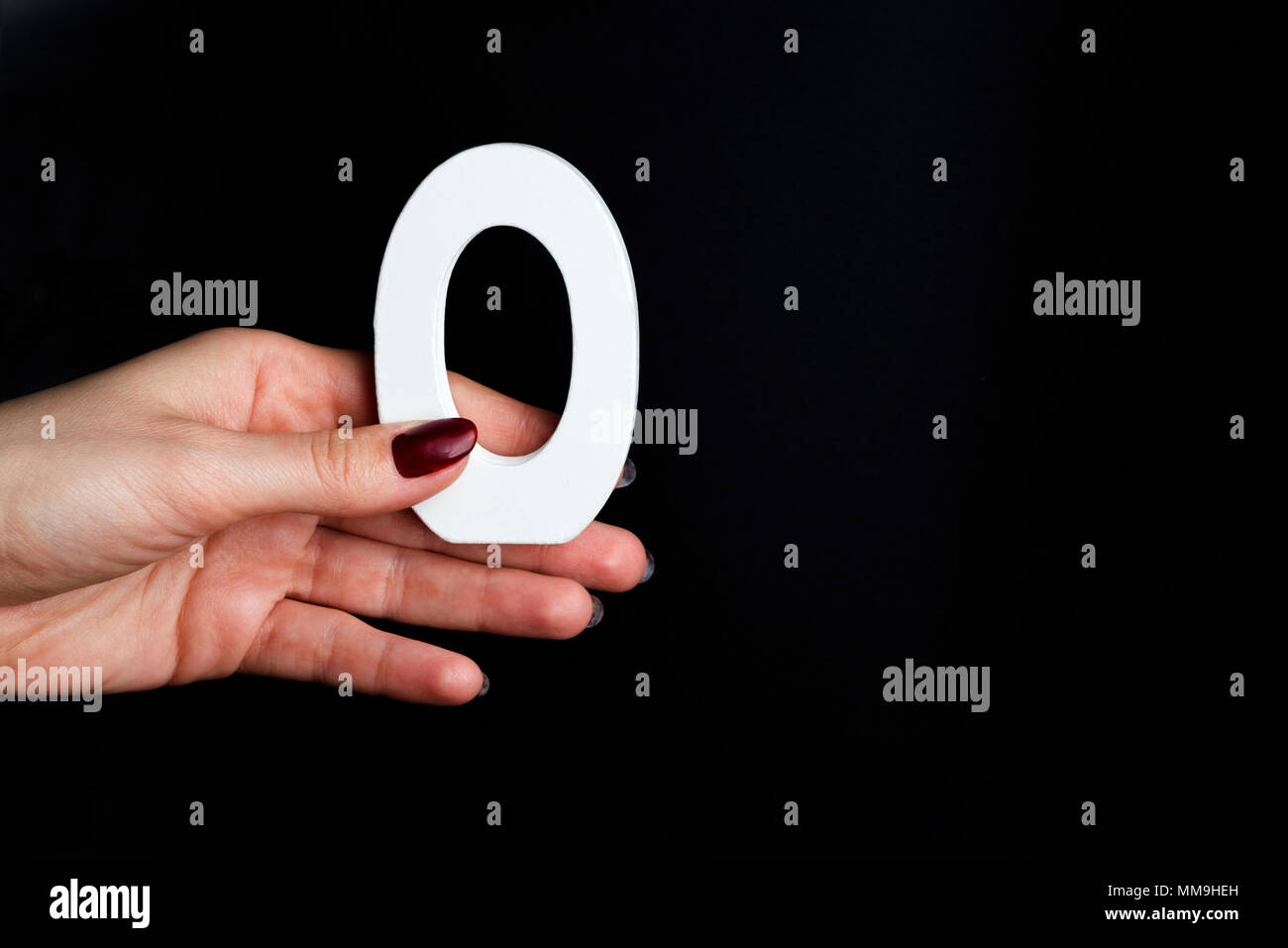 On a black background, female hand with number zero Stock Photo - Alamy