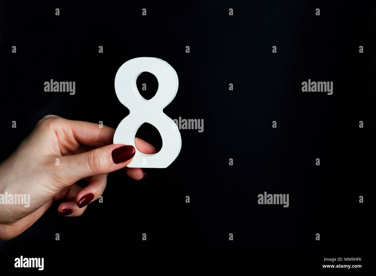 On a black background, female hand with a figure eight Stock Photo - Alamy