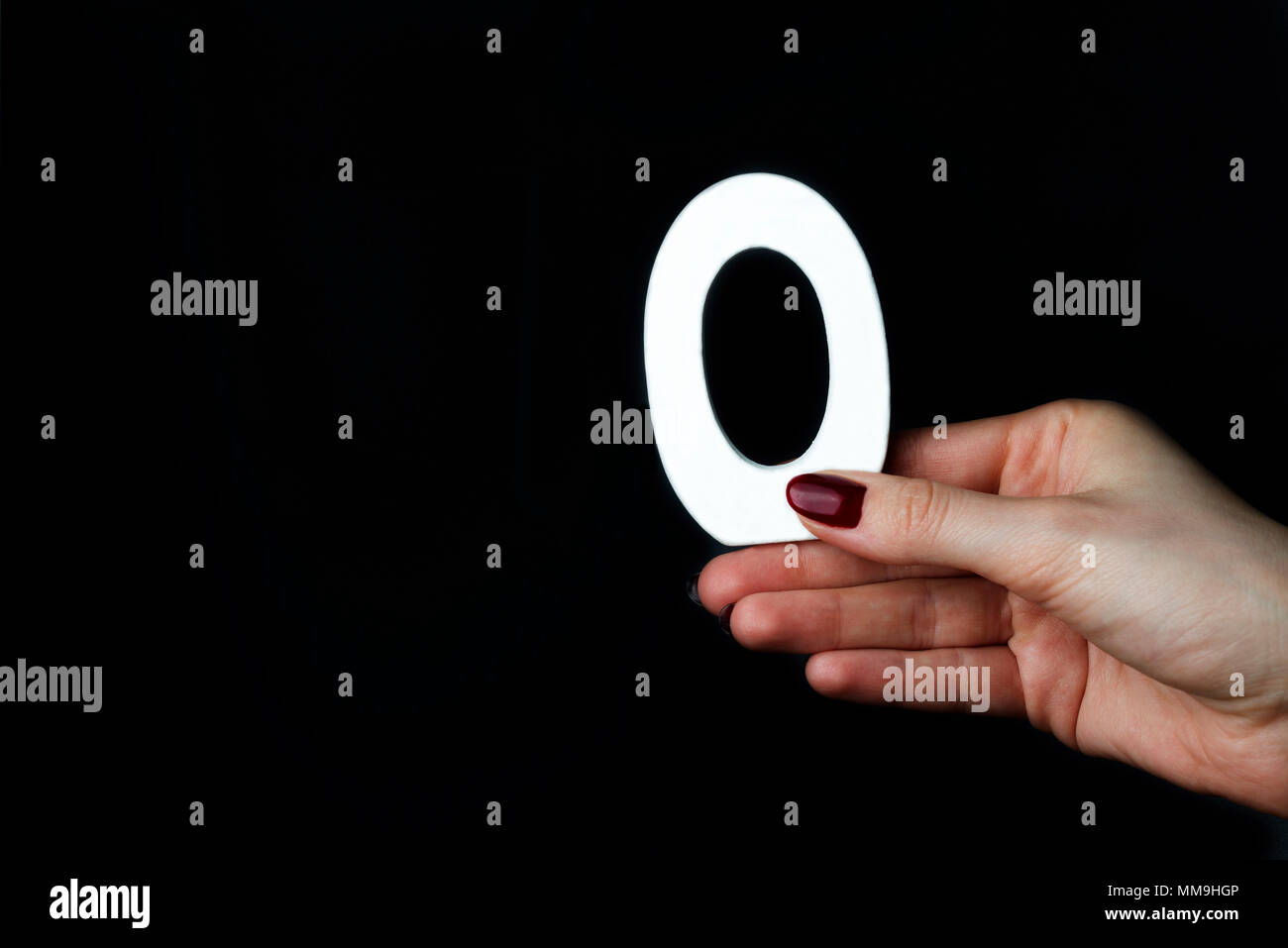 On a black background, female hand with number zero Stock Photo - Alamy