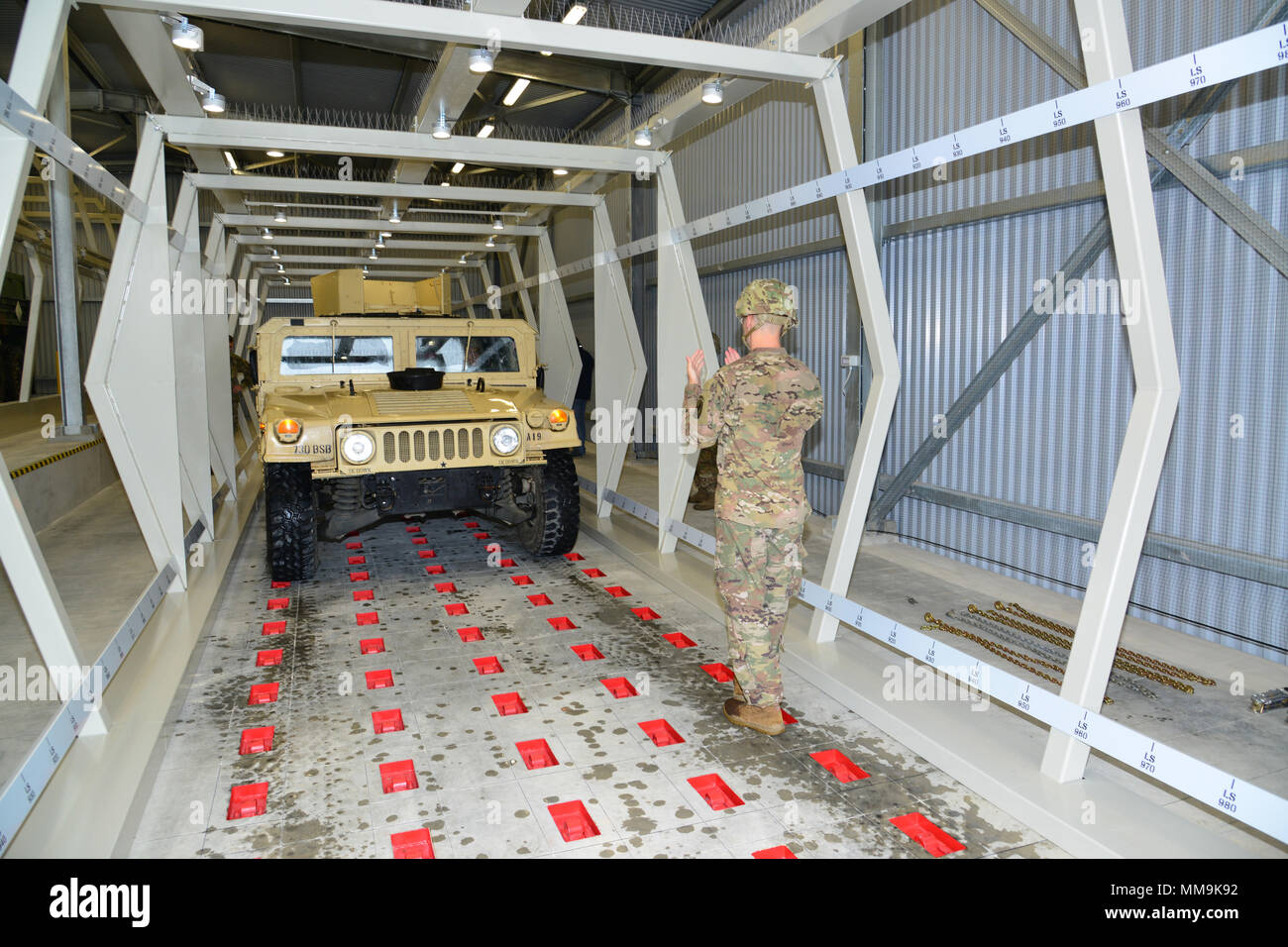 A High Mobility Multipurpose Wheeled Vehicle (HMMWV) is loaded into a C ...