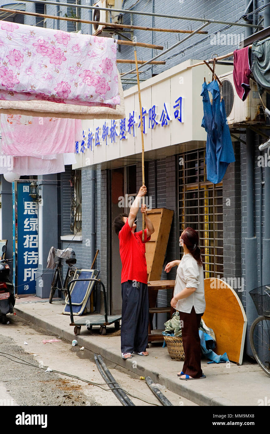 Man hanging clothes on the clothesline, in Wufu Halley, Shanghai, China ...