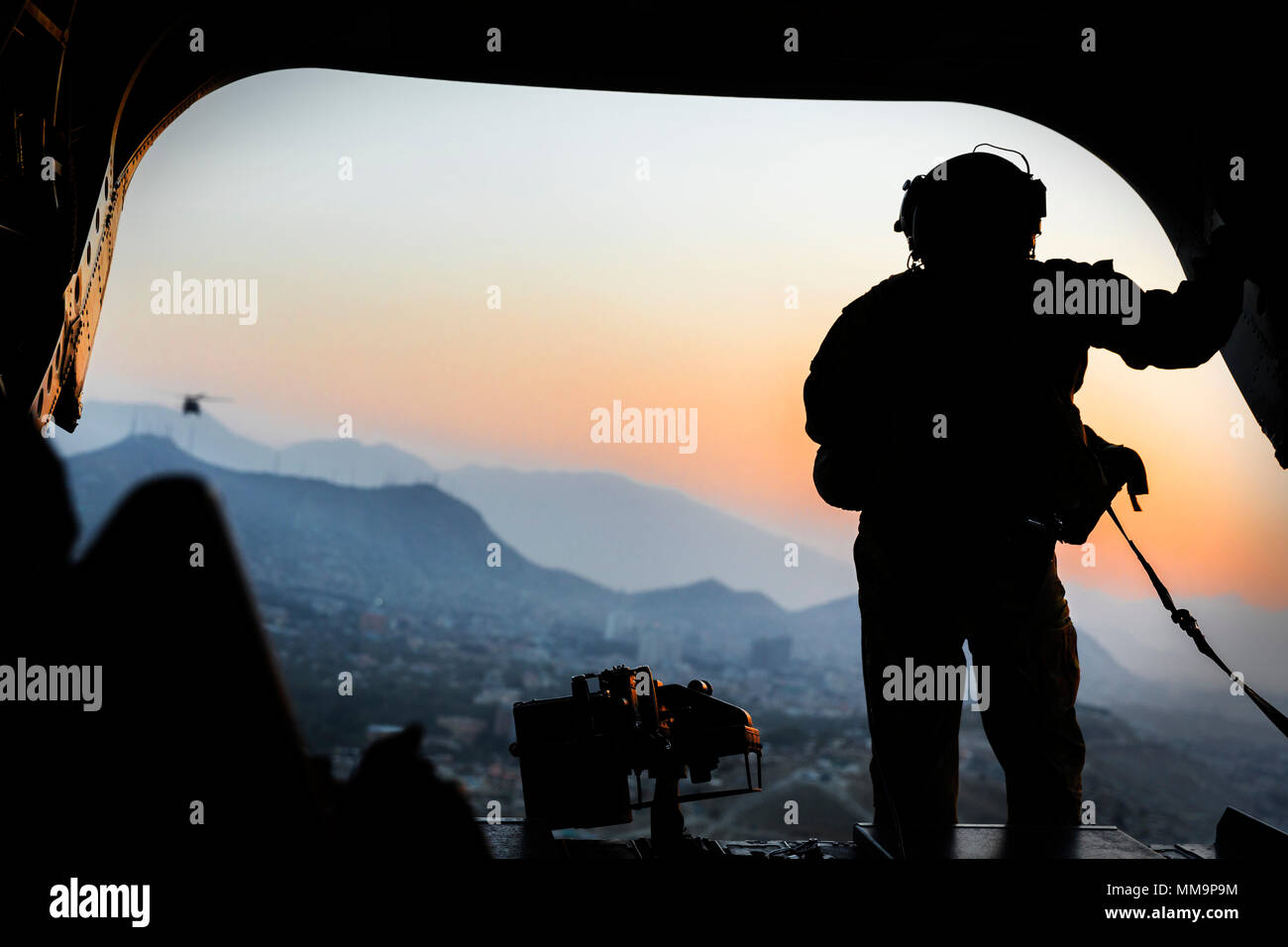 A United States Army loadmaster stands on the rear ramp of a CH-47F ...