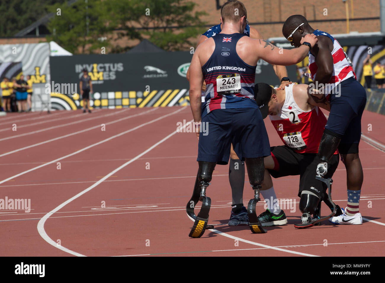 Invictus Games athletes surround a fellow athlete at the finish line at ...