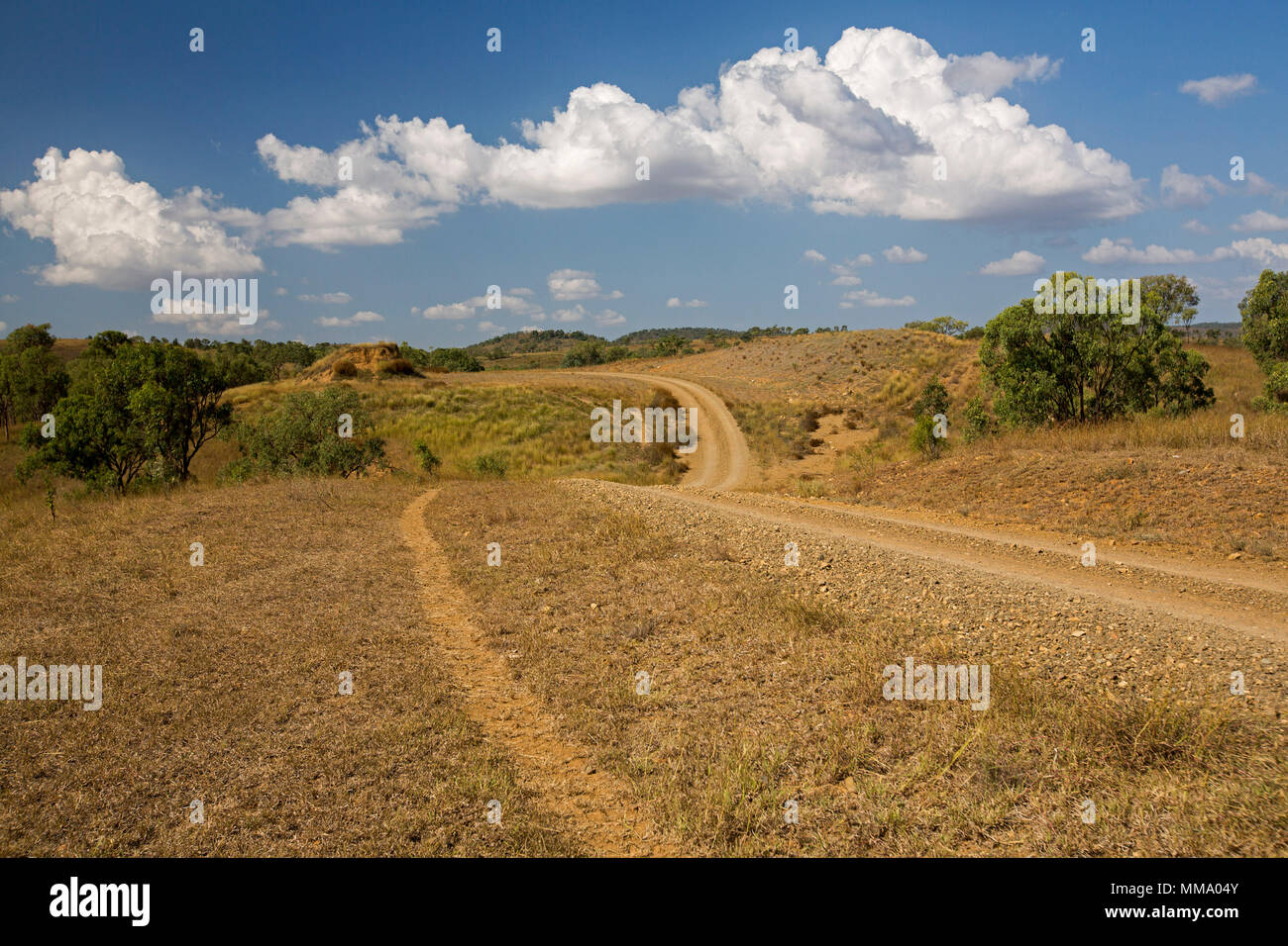 Undulating landscape with narrow track / road meandering over low hills ...