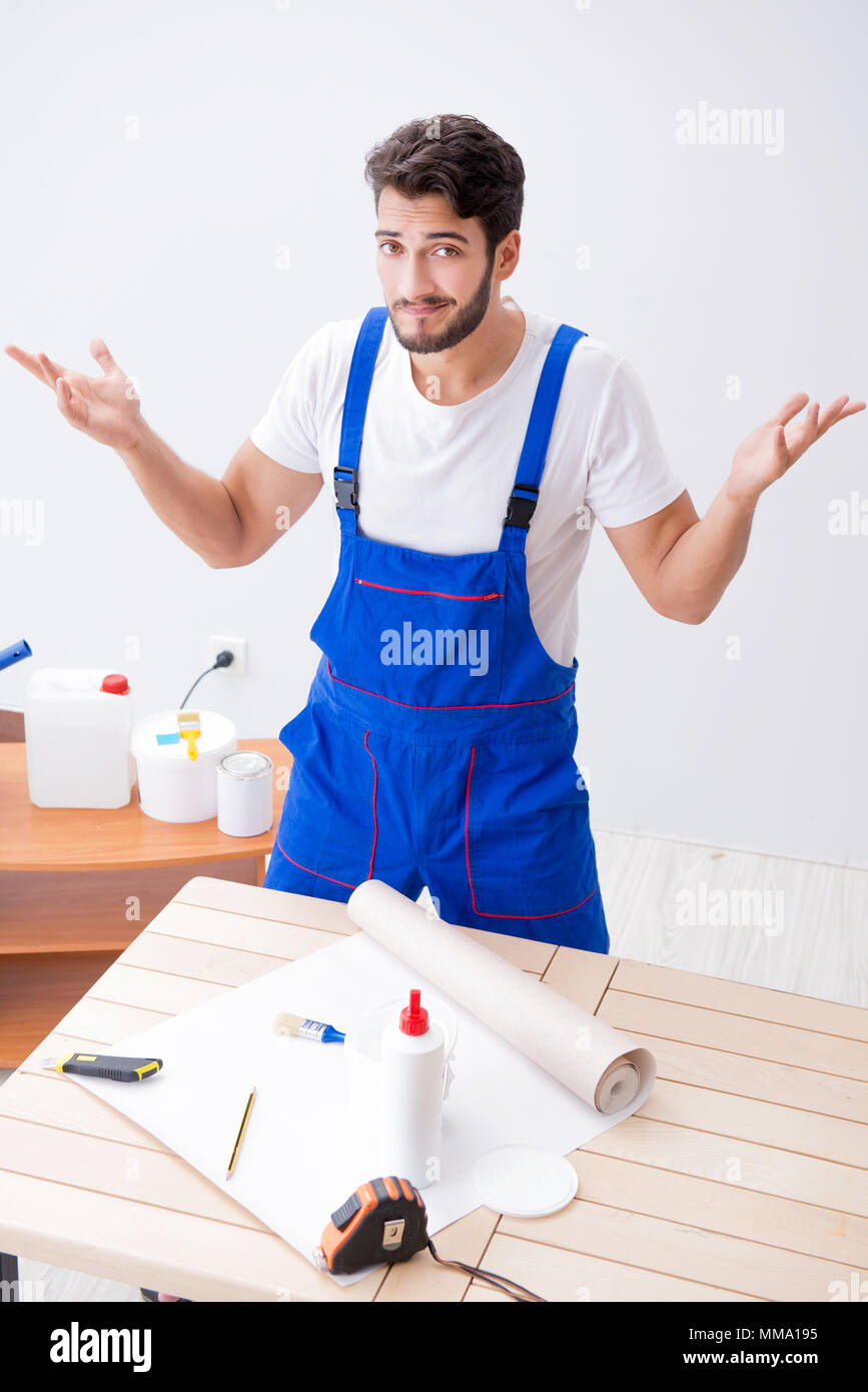 Worker working on wallpaper during refurbishment Stock Photo - Alamy