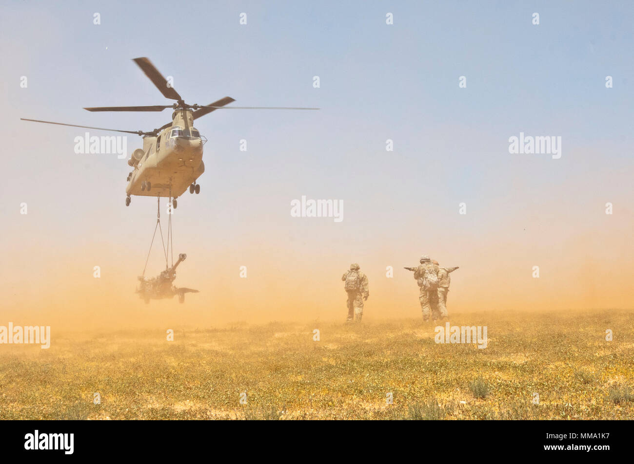 A CH-47 Chinook prepares to deposit a secured M777 Howitzer during a ...