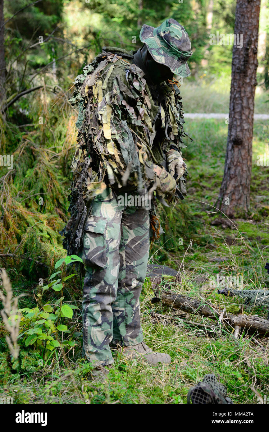 A Portuguese soldier puts on a ghillie suit during the European Best ...