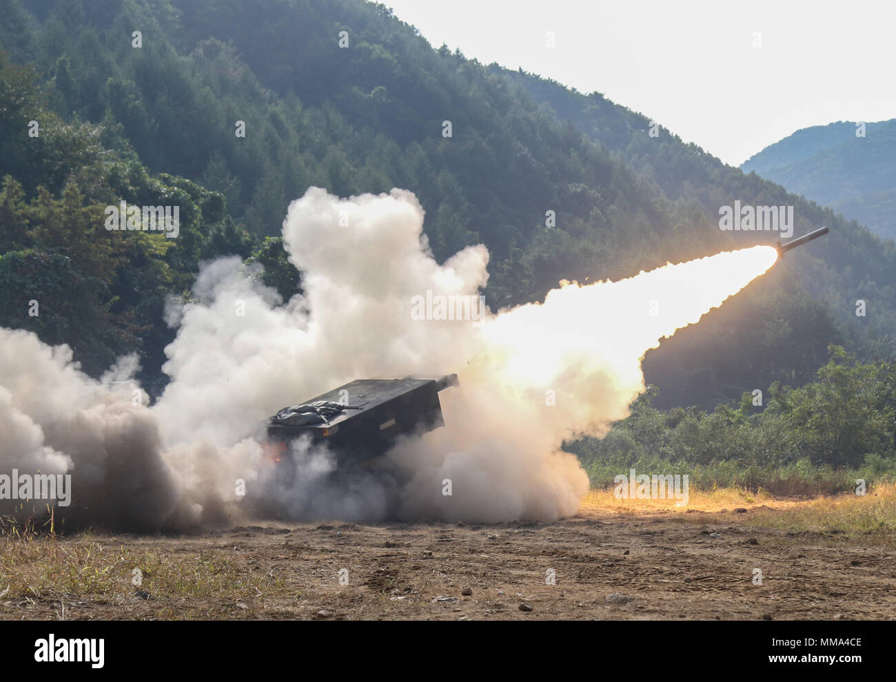An M270 multiple launch rocket system fires during a live fire training ...