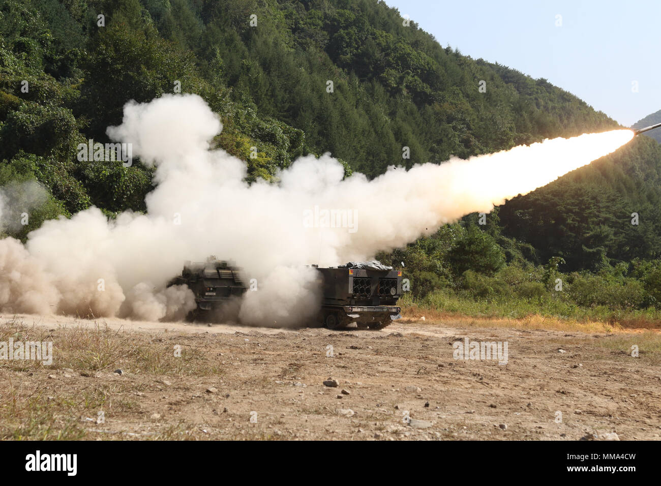 An M270 multiple launch rocket system fires during a live fire training ...