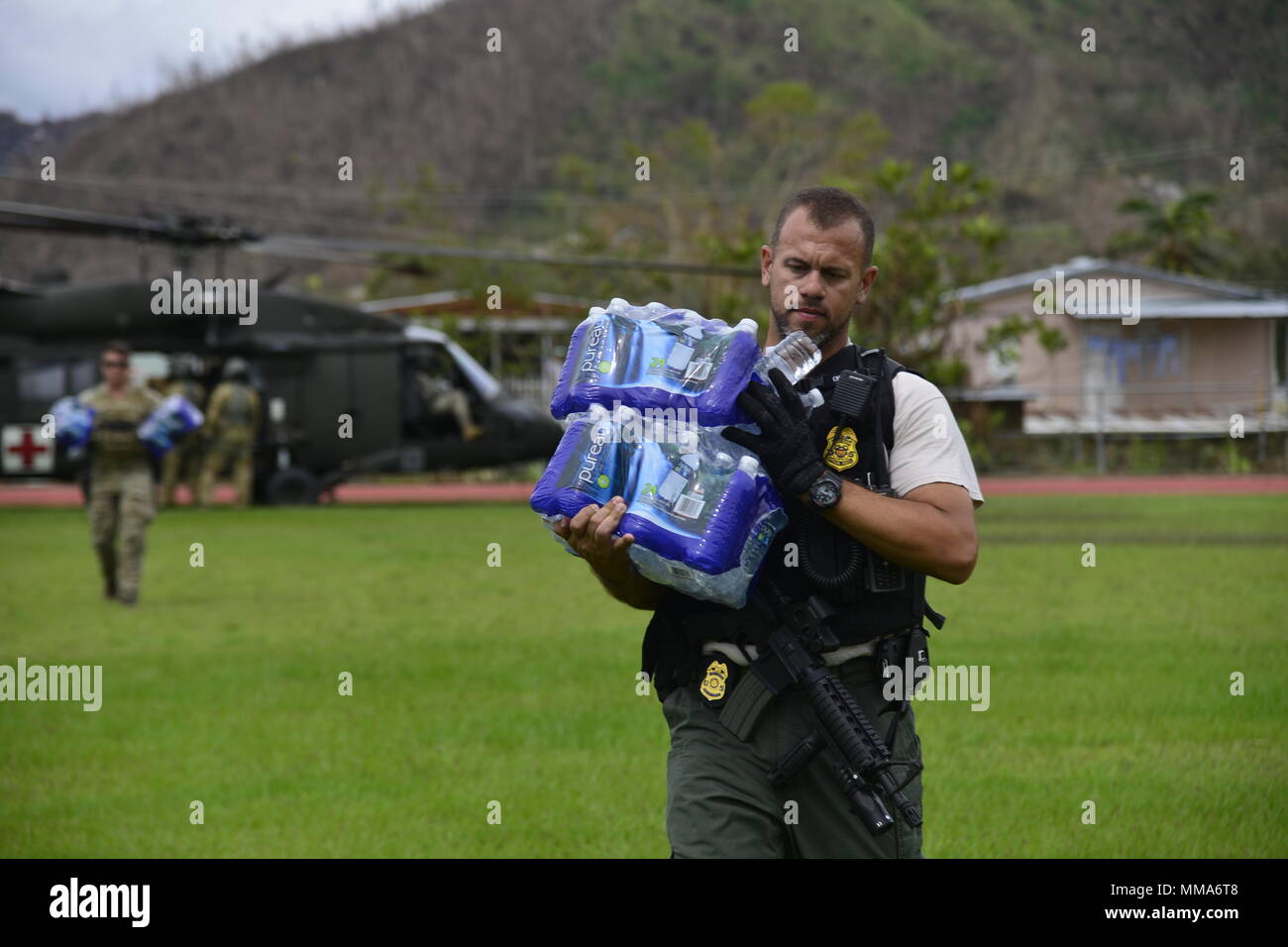 U.S. Coast Guard Investigative Service agent, Ferdinand Acosta, carries ...