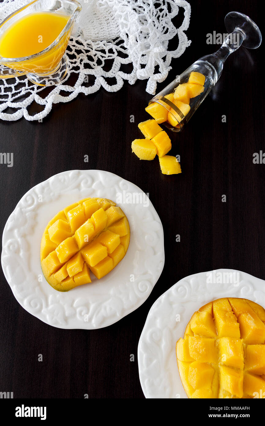 Mango fruit cubes and mango juice puree on dark wooden background ...