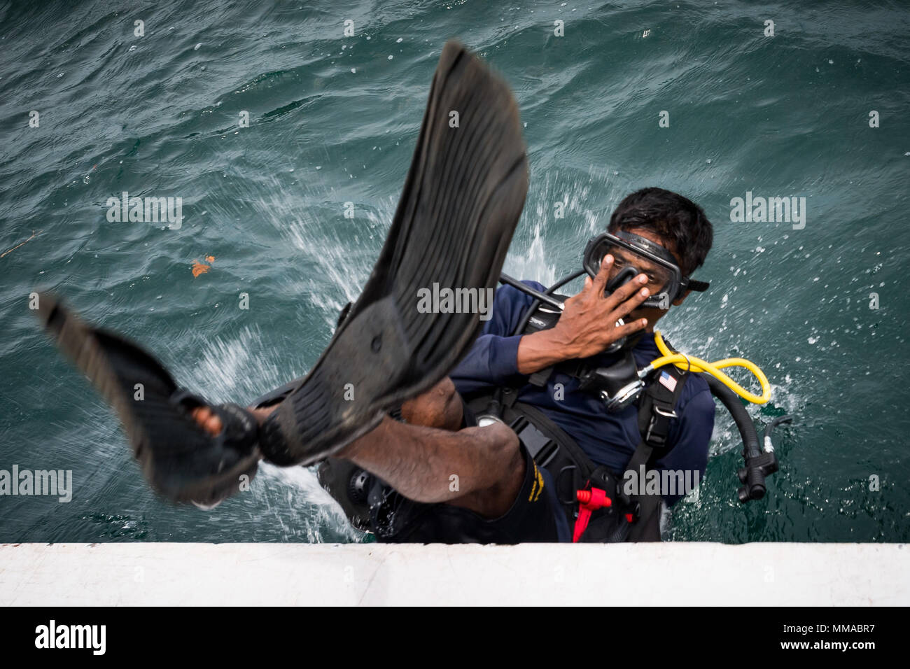 A Sri Lankan Navy Diver enters the water for diving operations with ...