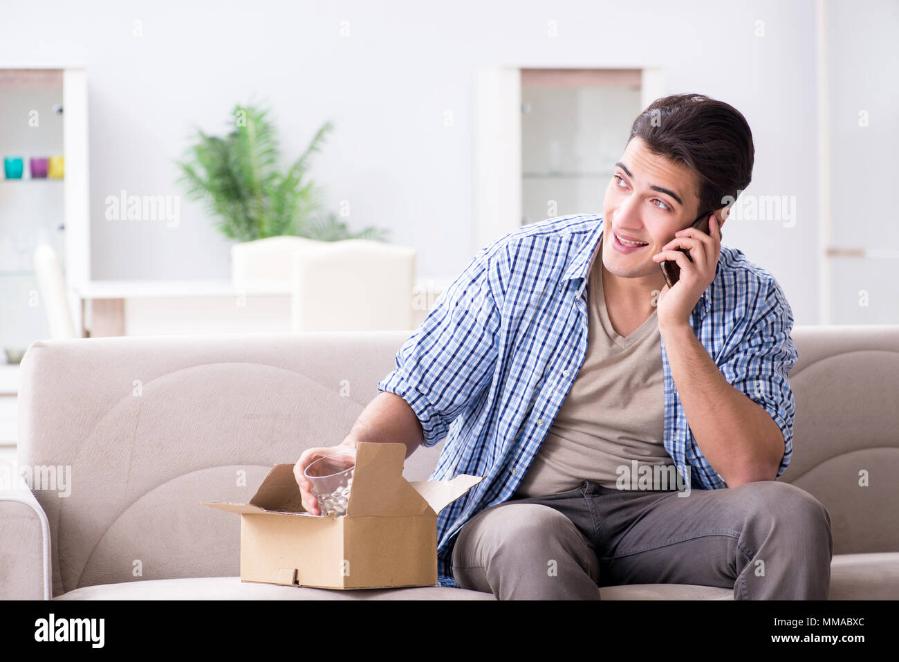 Man receiving parcel at home Stock Photo - Alamy