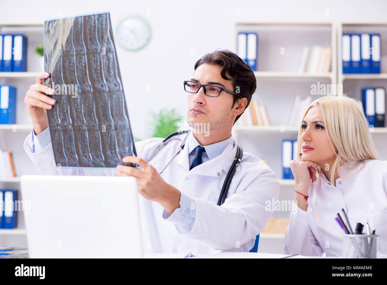 Two doctors examining x-ray images of patient for diagnosis Stock Photo ...