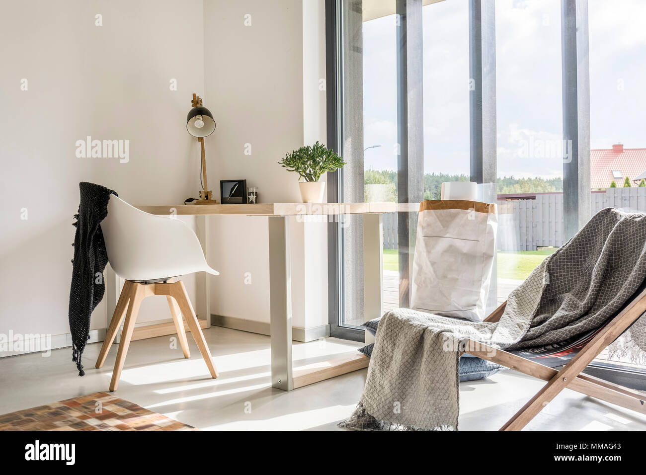 White room with deckchair, wooden desk, chair and window wall Stock ...