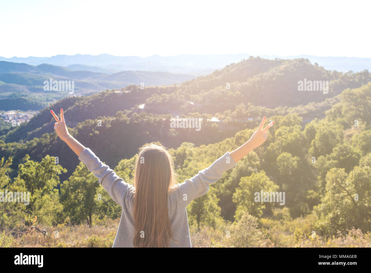 Beautiful women showing peace sign while enjoying mountains landscape ...