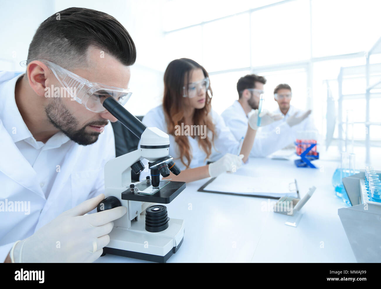 male laboratory technician looking at samples in the microscope Stock ...