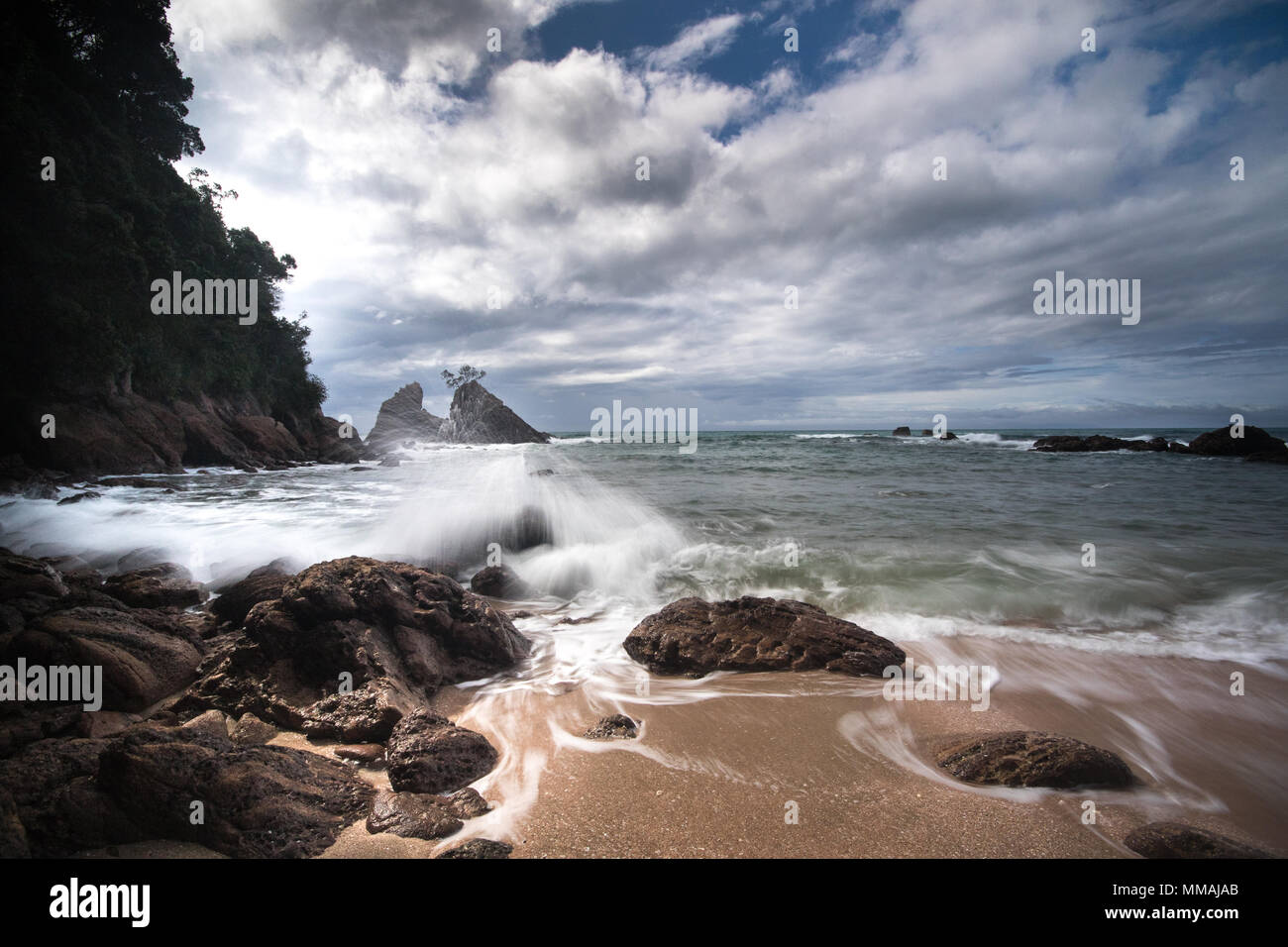A cliff face in a secluded bay with a interesting rock formation Stock ...