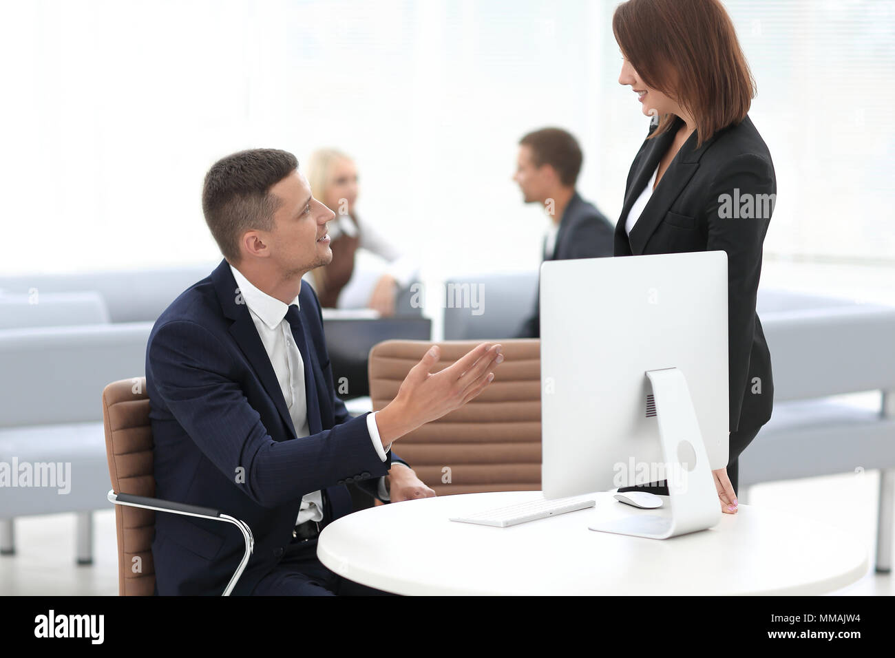 employees sitting behind a Desk in the office Stock Photo - Alamy