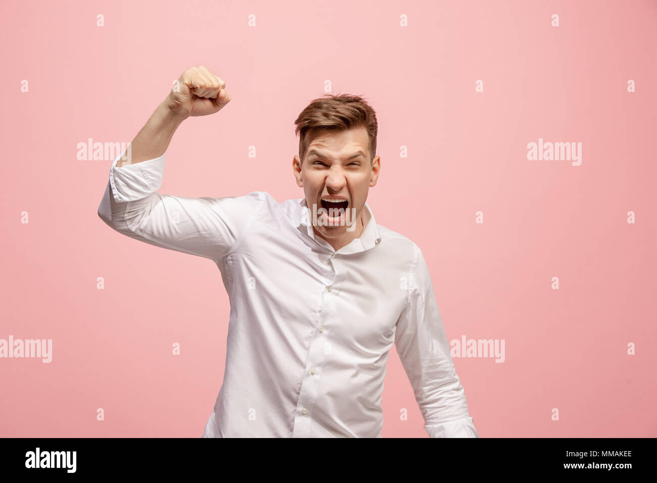 The young emotional angry man screaming on pink studio background Stock ...