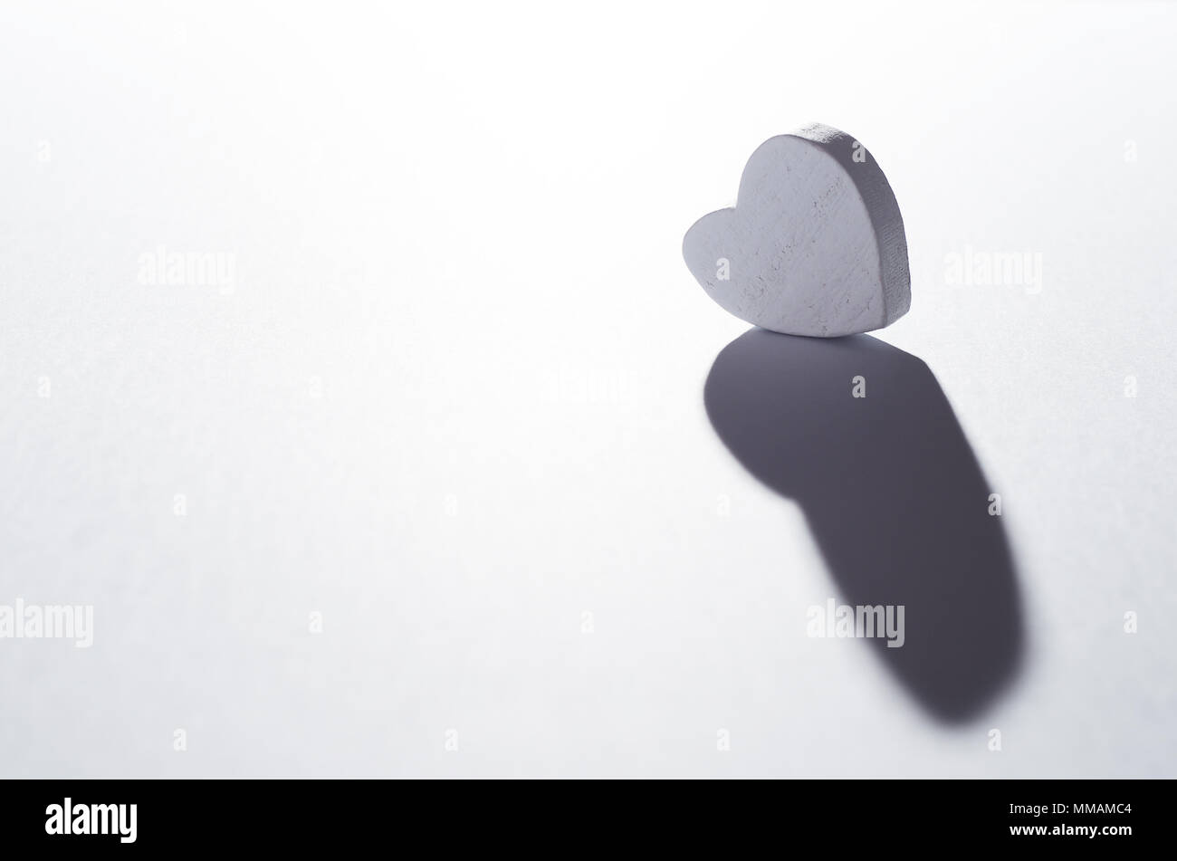 Heart and its shadow over bright background Stock Photo - Alamy