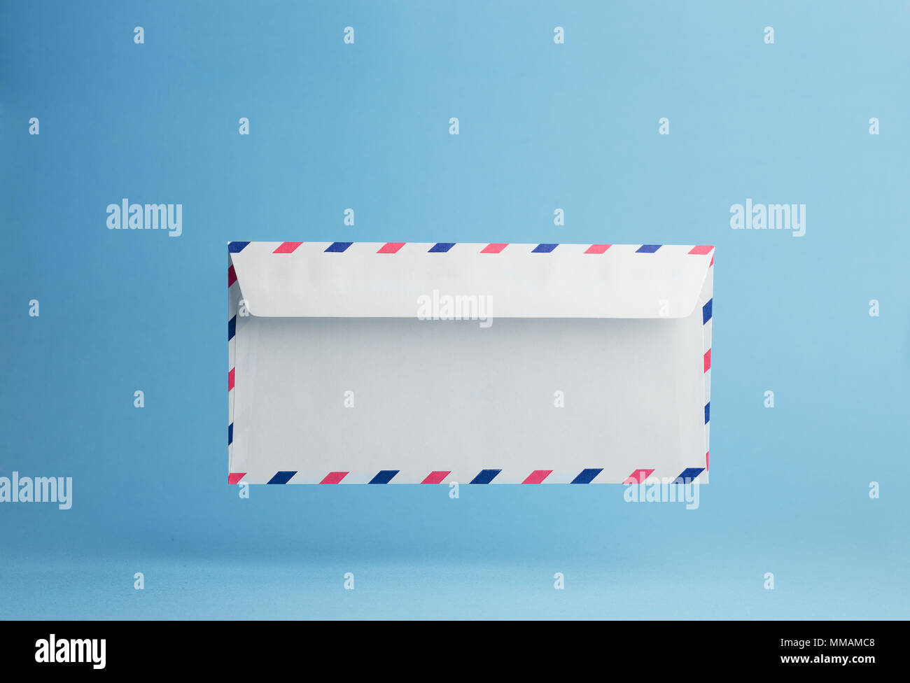 Envelope falling on the ground, blue background with negative space ...
