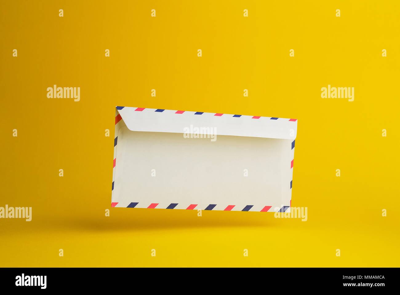 Envelope falling on the ground, yellow background with negative space ...