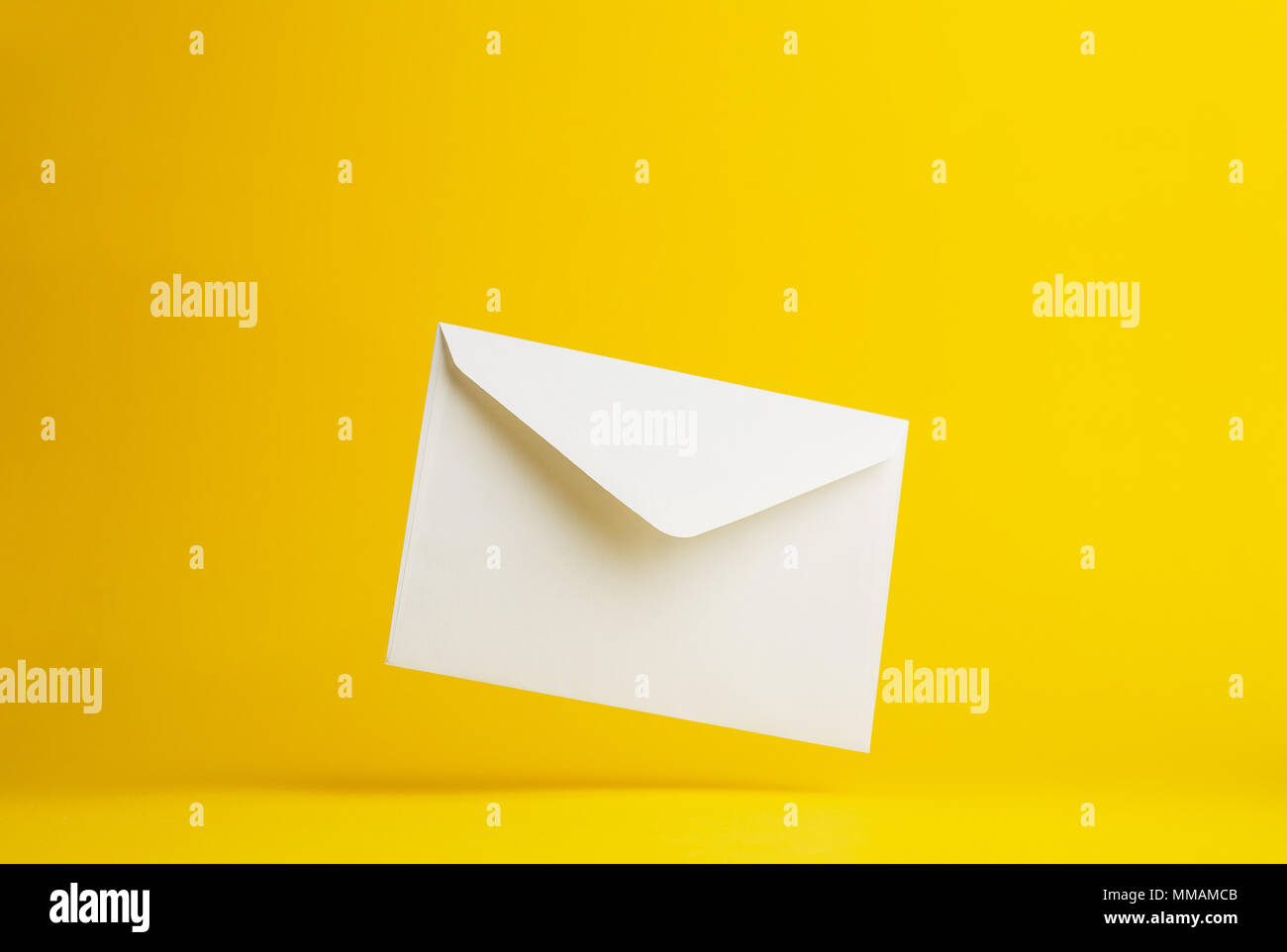 Envelope falling on the ground, yellow background with negative space ...