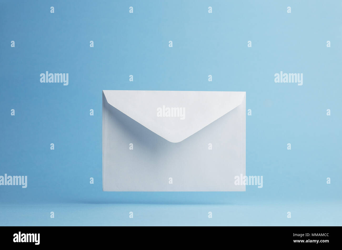 Envelope falling on the ground, blue background with negative space ...