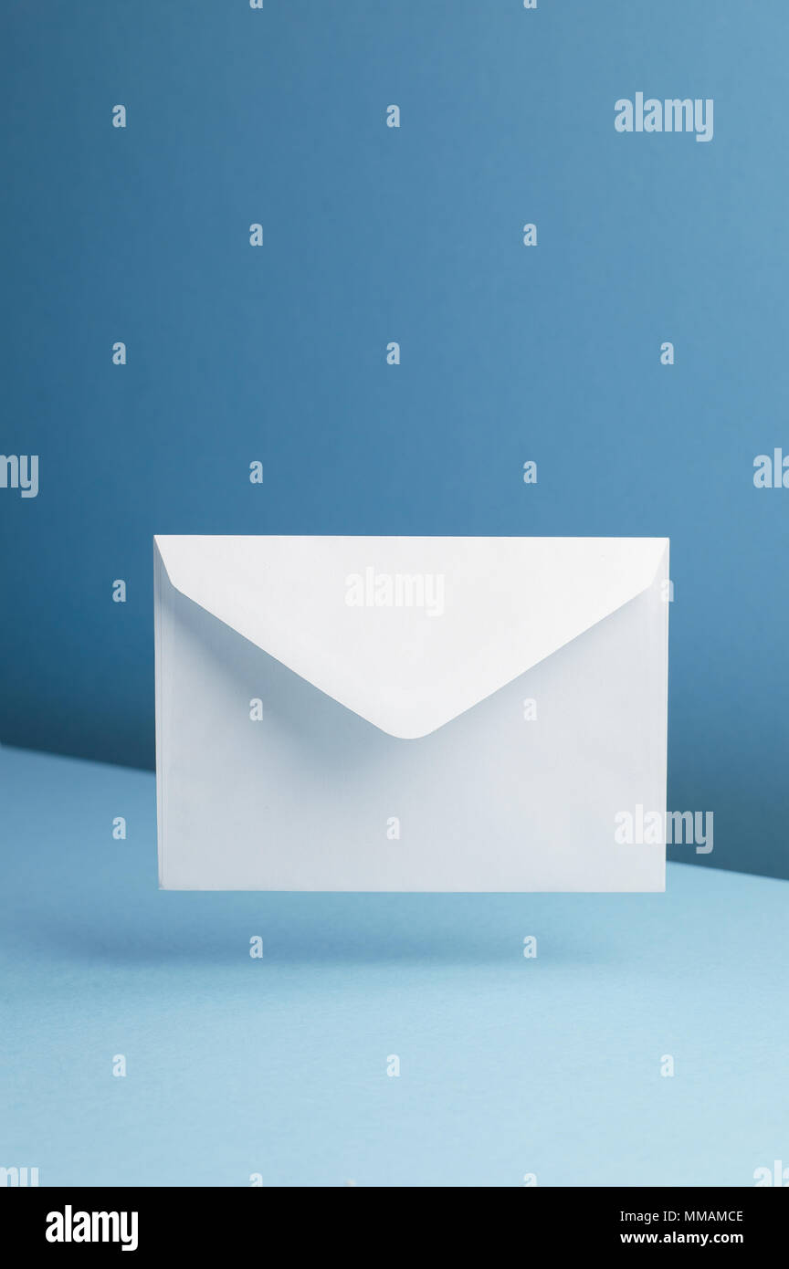 Envelope falling on the ground, blue background with negative space ...