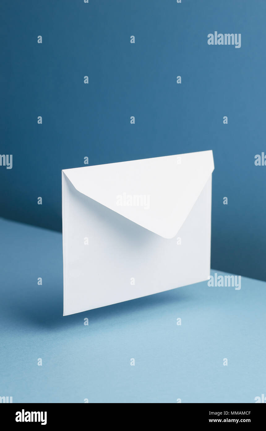 Envelope falling on the ground, blue background with negative space ...