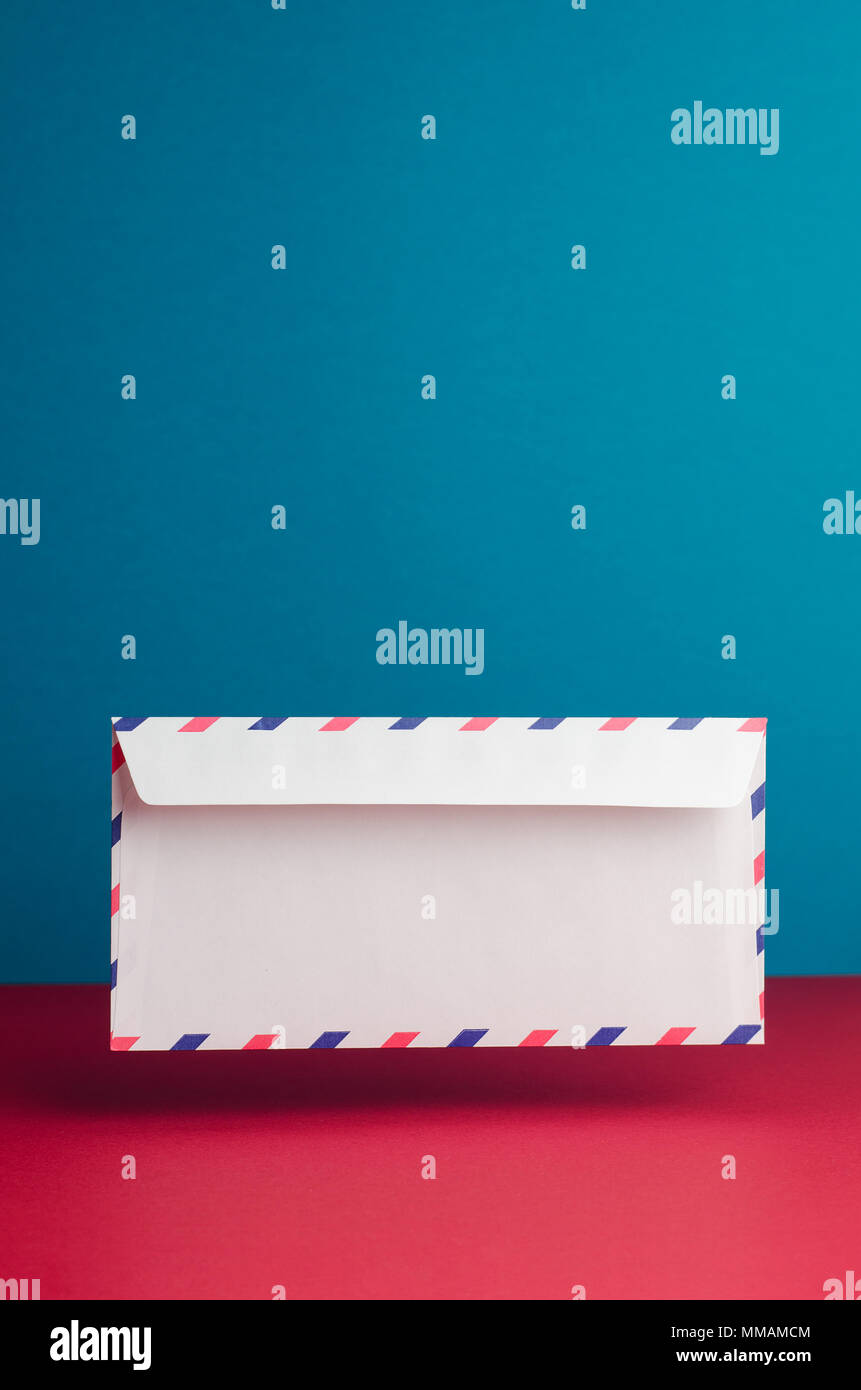 Envelope in the air over blue and red background with negative space ...