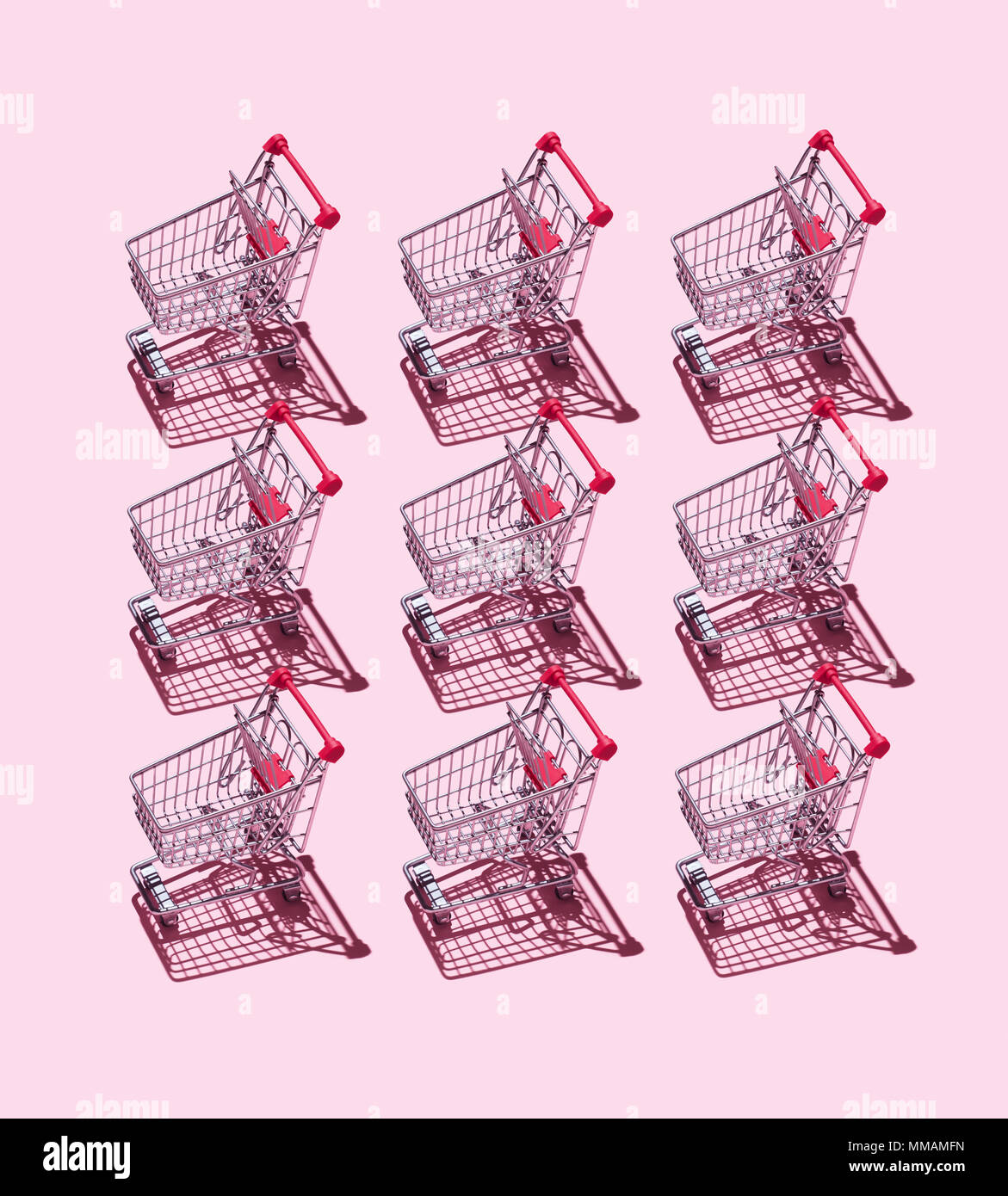 Multiple Shopping Carts organized over pink background Stock Photo - Alamy