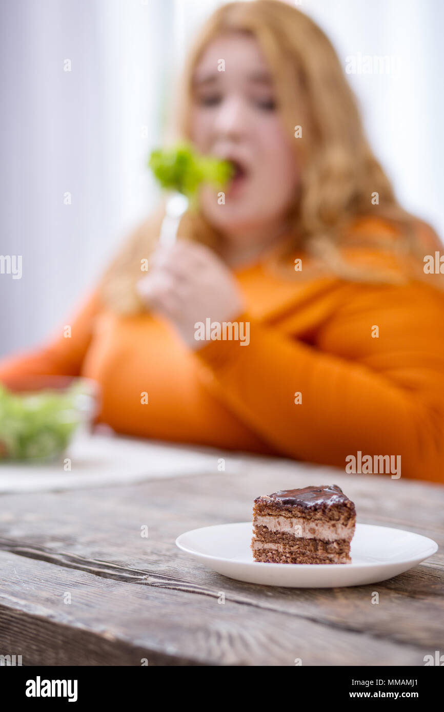 Miserable plump woman looking at cookies Stock Photo - Alamy
