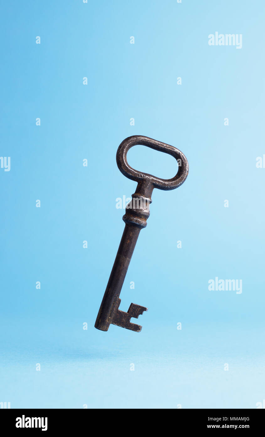 Vintage Key falling over blue background Stock Photo - Alamy