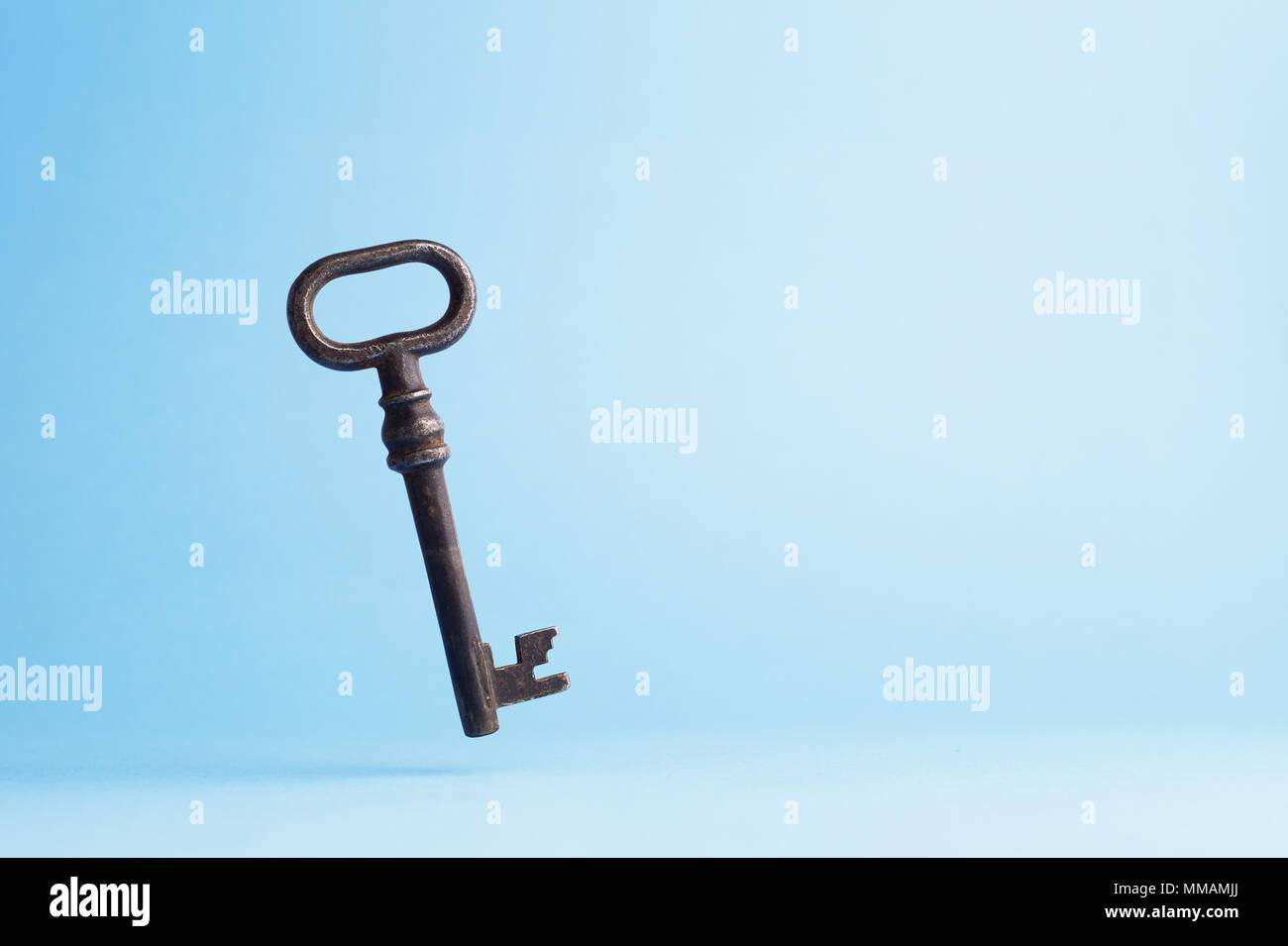 Vintage Key falling over blue background with negative space Stock ...