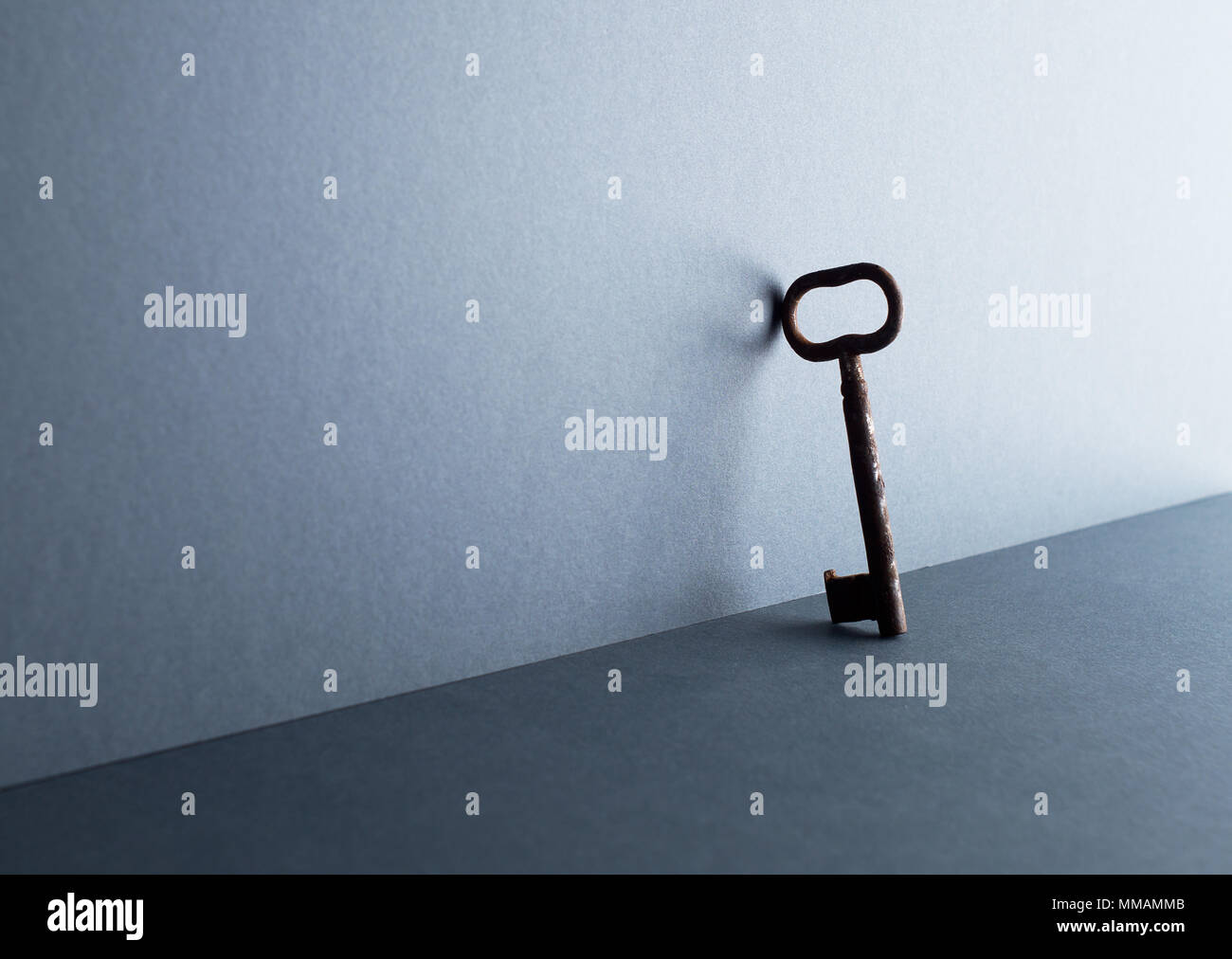 Silhouette of an vintage key leaning against the dark blue background ...